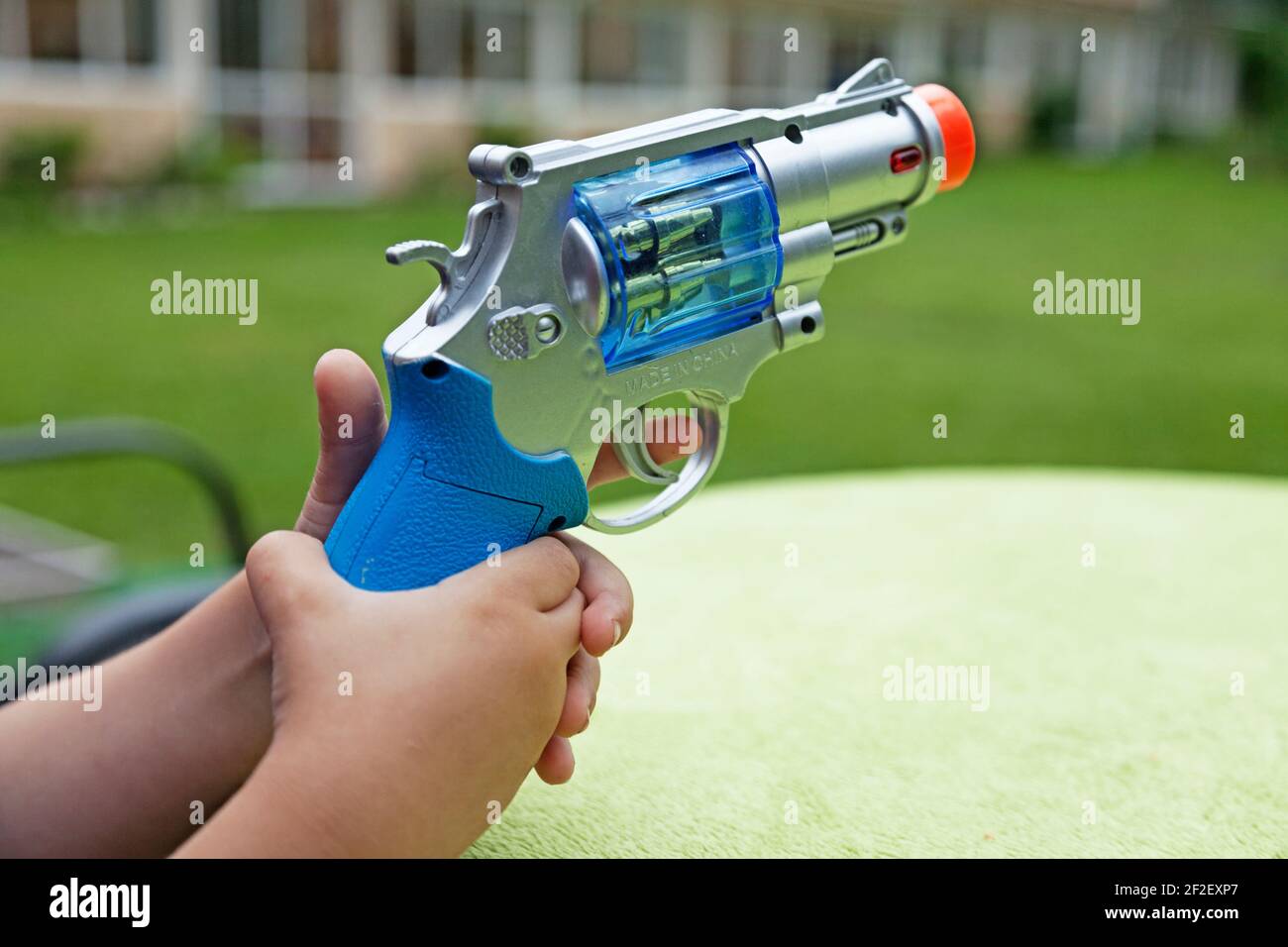 a child holds a plastic toy gun with both hands Stock Photo - Alamy
