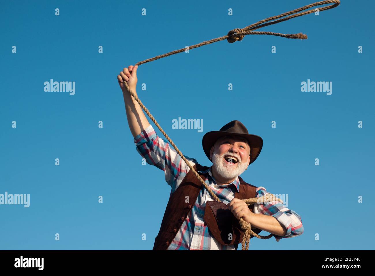Old wild west cowboy with lasso rope. Bearded western man with brown ...