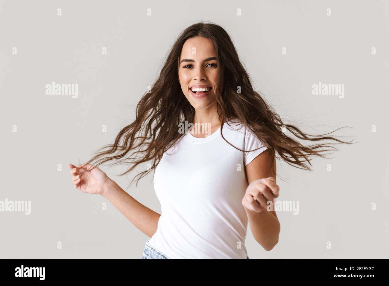 Happy beautiful girl smiling and dancing on camera isolated over white ...