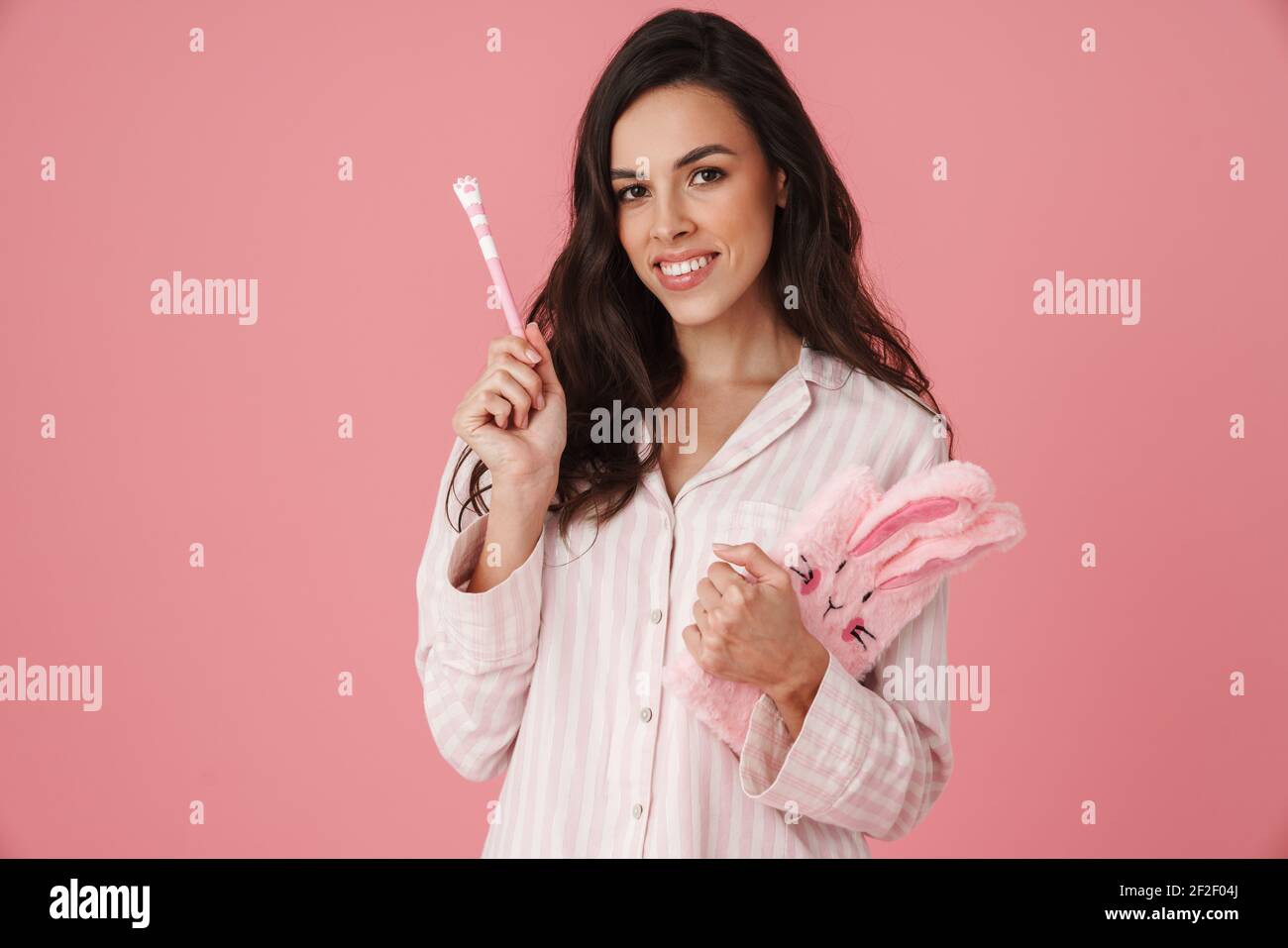 Happy beautiful woman in pajama posing with pen and bunny diary ...