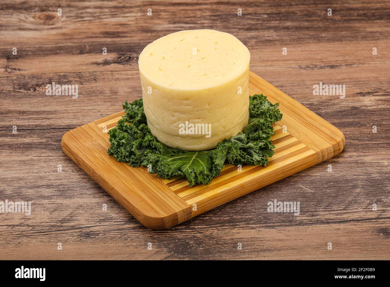 Yellow round dairy soft cheese piece Stock Photo - Alamy