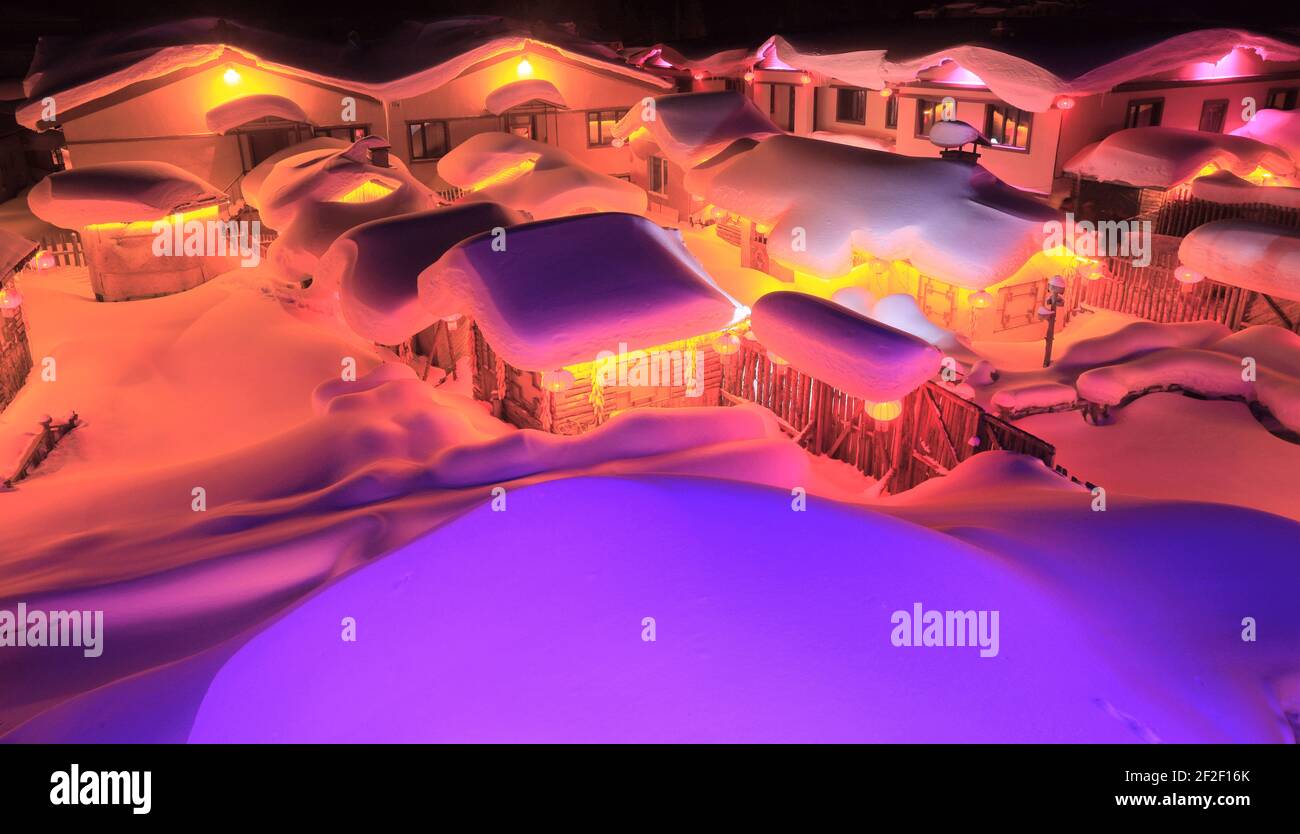 A few feet of snow glows in the night light of Mudanjiang City ...