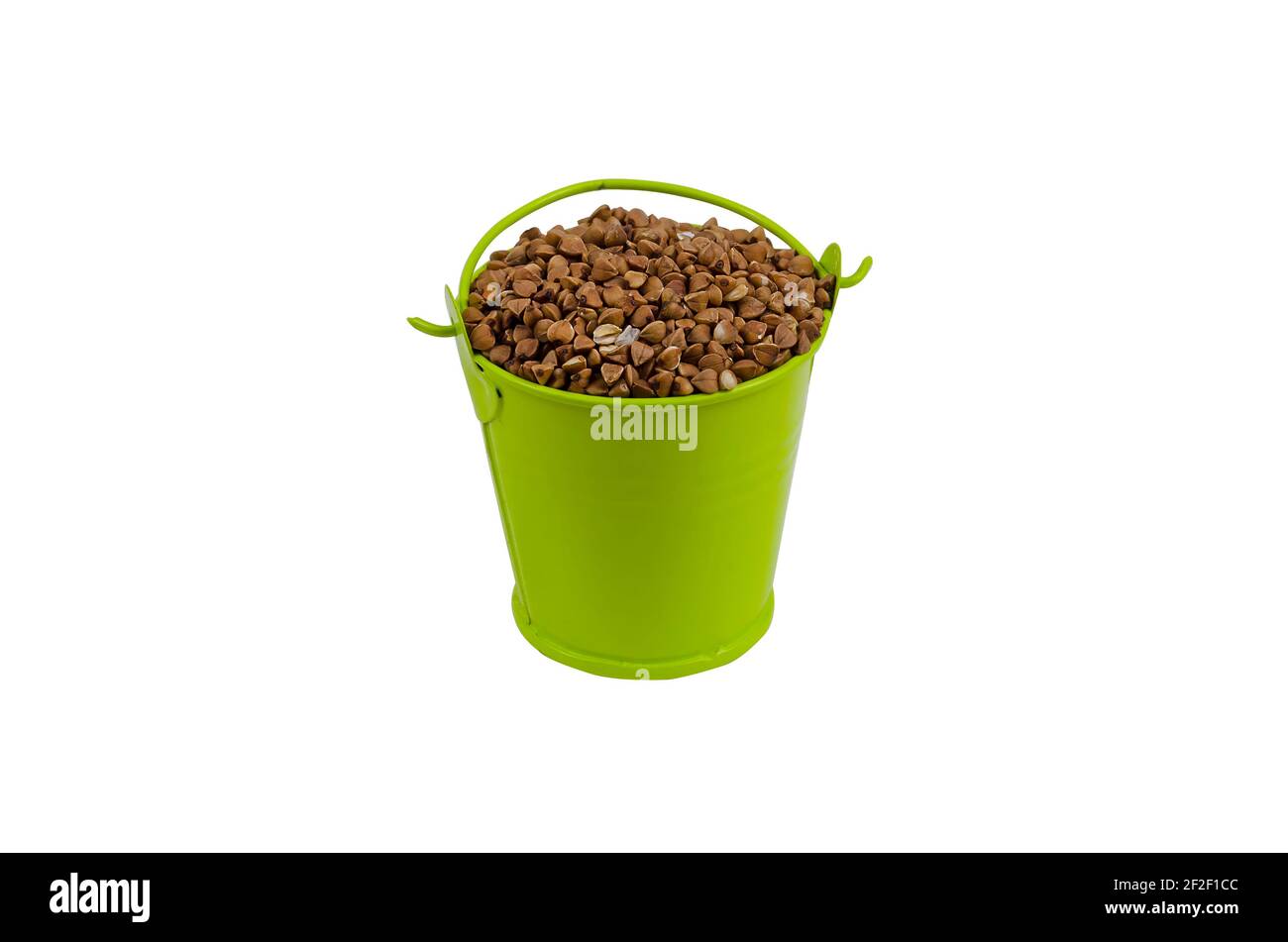 Full green bucket of dry buckwheat on a white plate. Grains ready for ...
