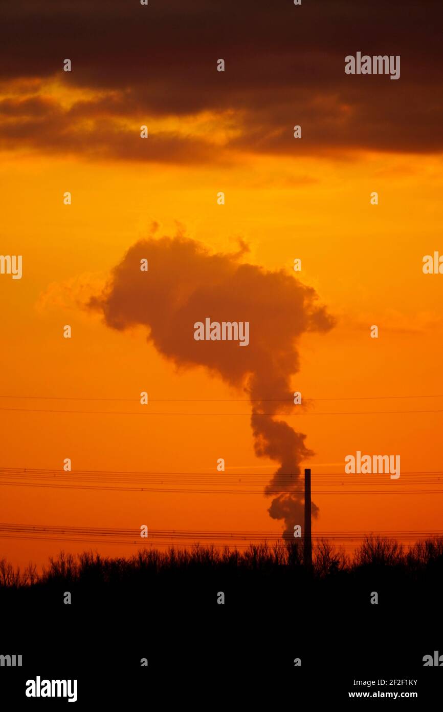 Cloud of smoke as the sun sets. Orange colors. Environmental pollution ...