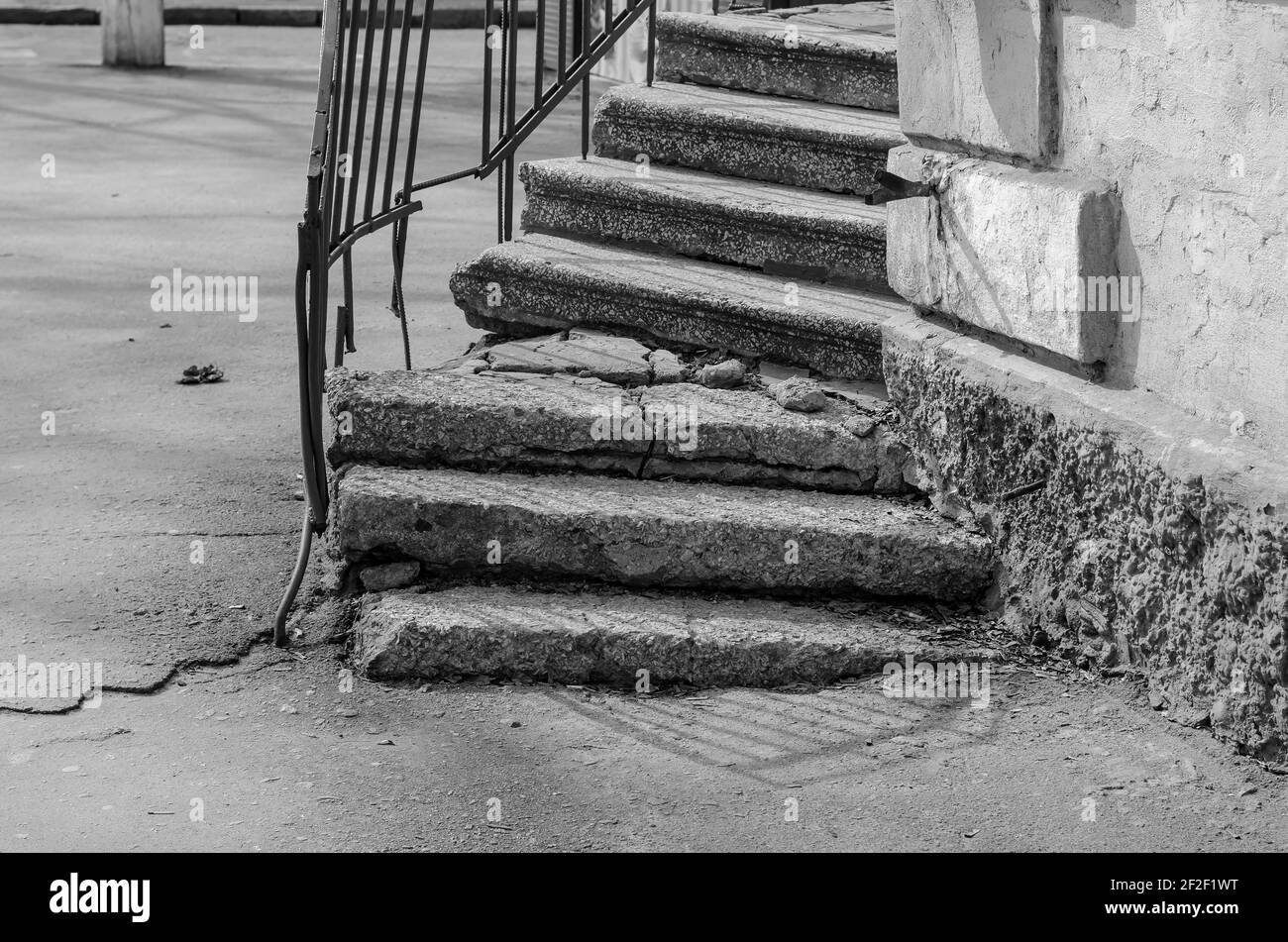 Old crumbling stone staircase with metal railings. Rusty railings line ...