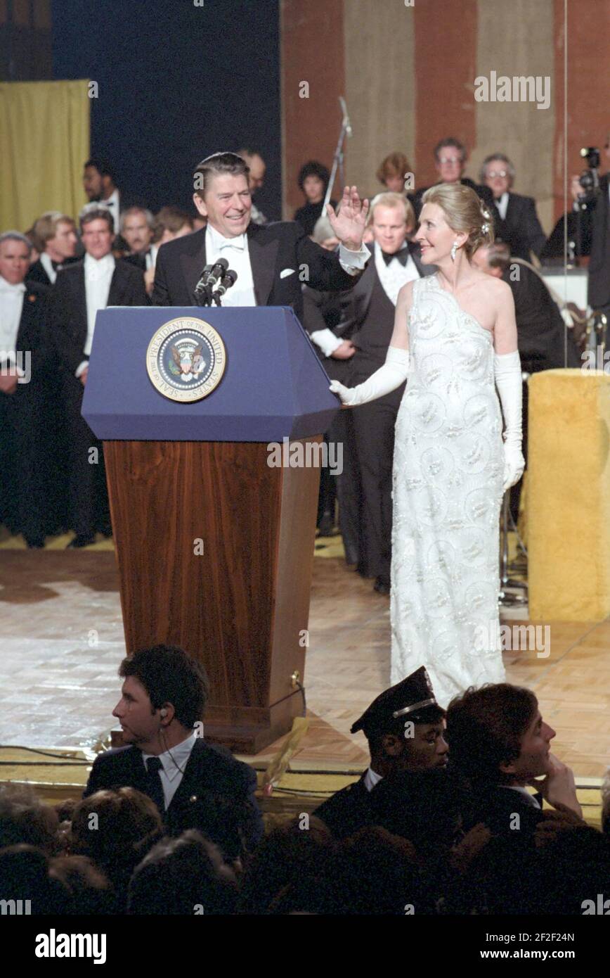 President Ronald Reagan and Nancy Reagan standing behind podium waving ...