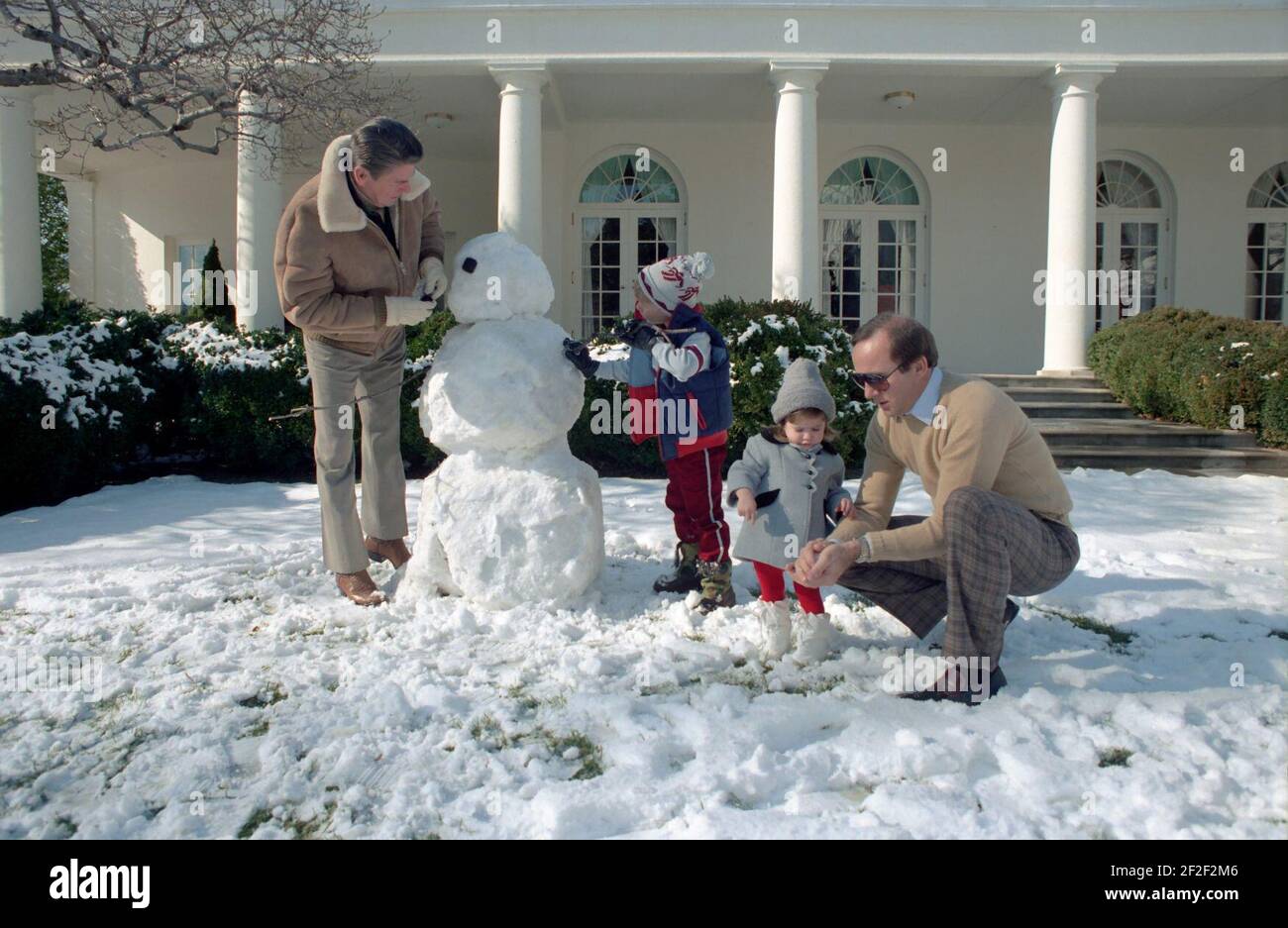 President Ronald Reagan building a snowman in the Rose Garden with ...