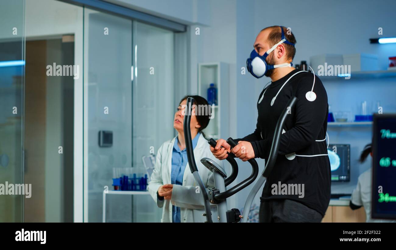 Medical researcher talking with sportsman and showing EKG scan on ...