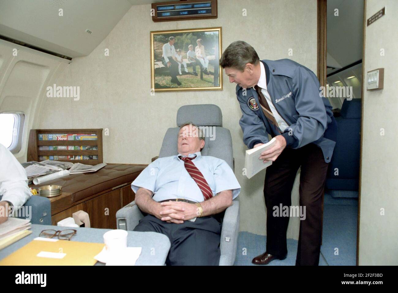 President Ronald Reagan showing papers to a sleeping Howard Baker ...