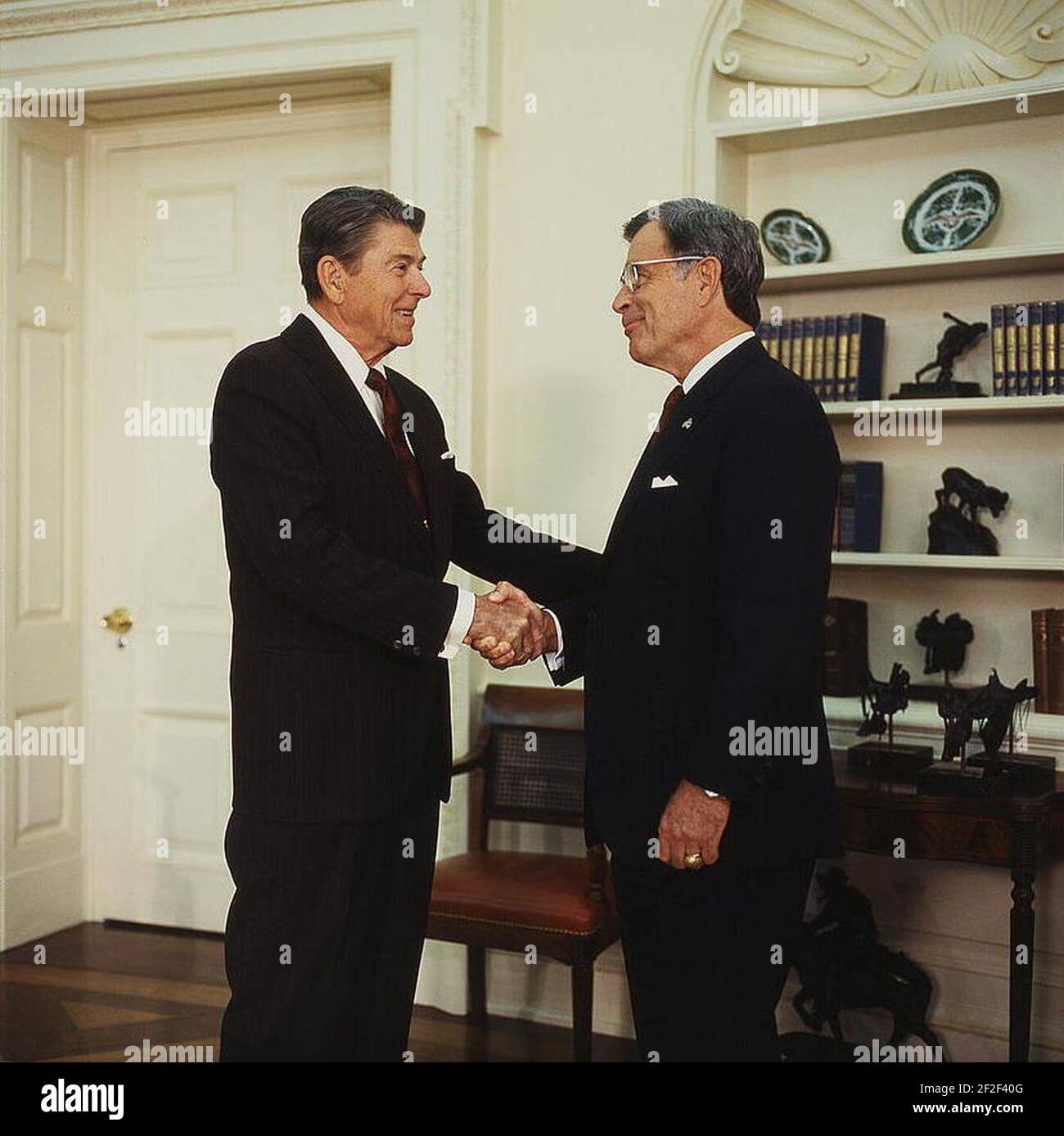 President Ronald Reagan, in the Oval Office, shaking hands with ...