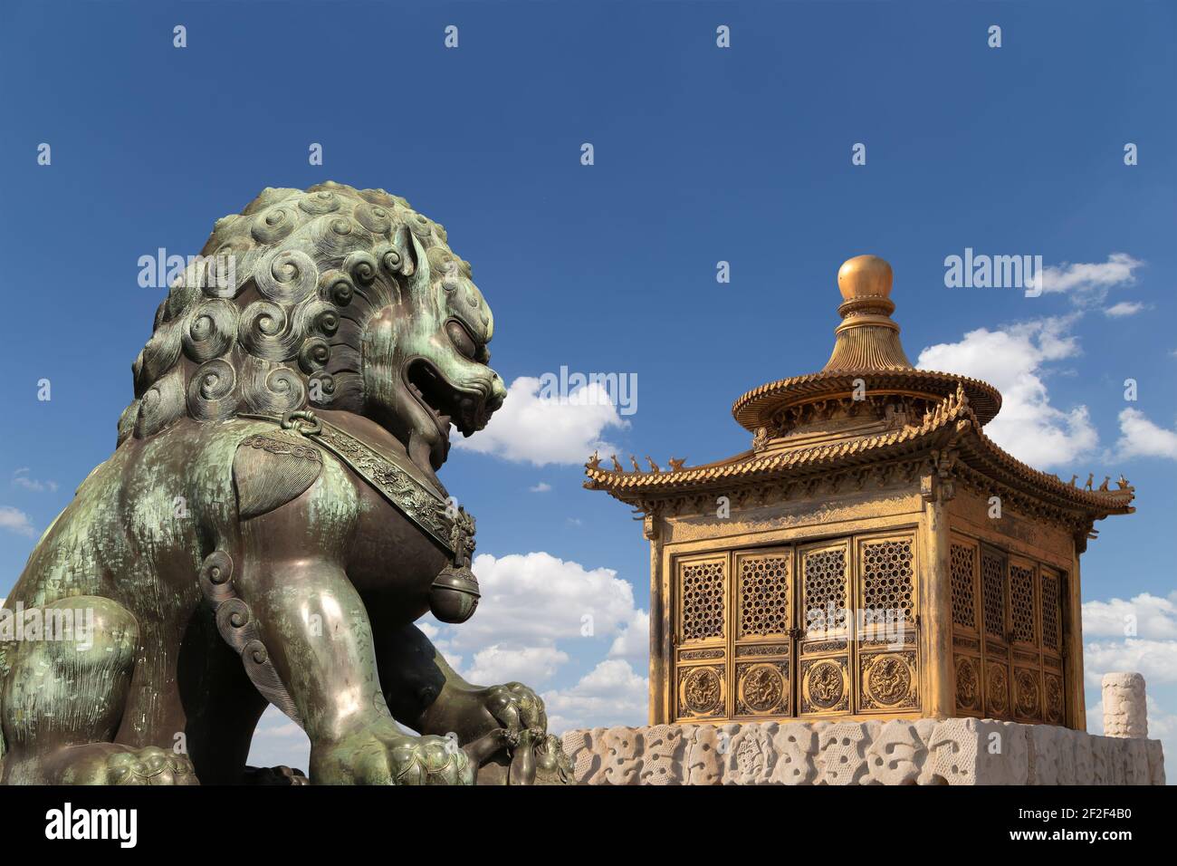 Bronze Guardian Lion Statue and bronze pagoda in the Forbidden City ...