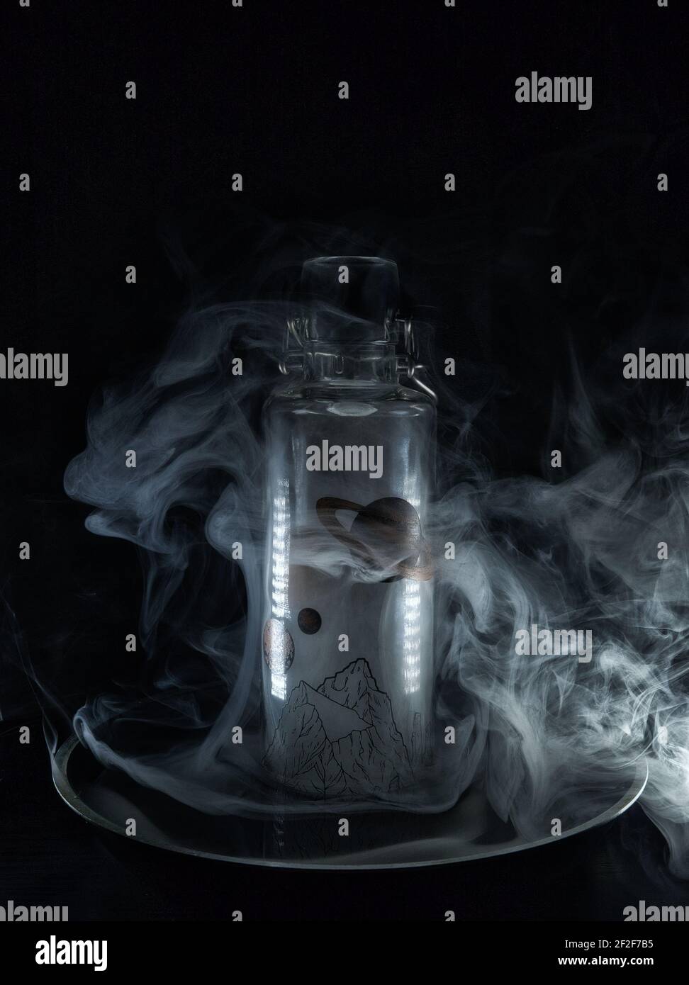 A glass bottle with white smoke around it in the darkness Stock Photo ...