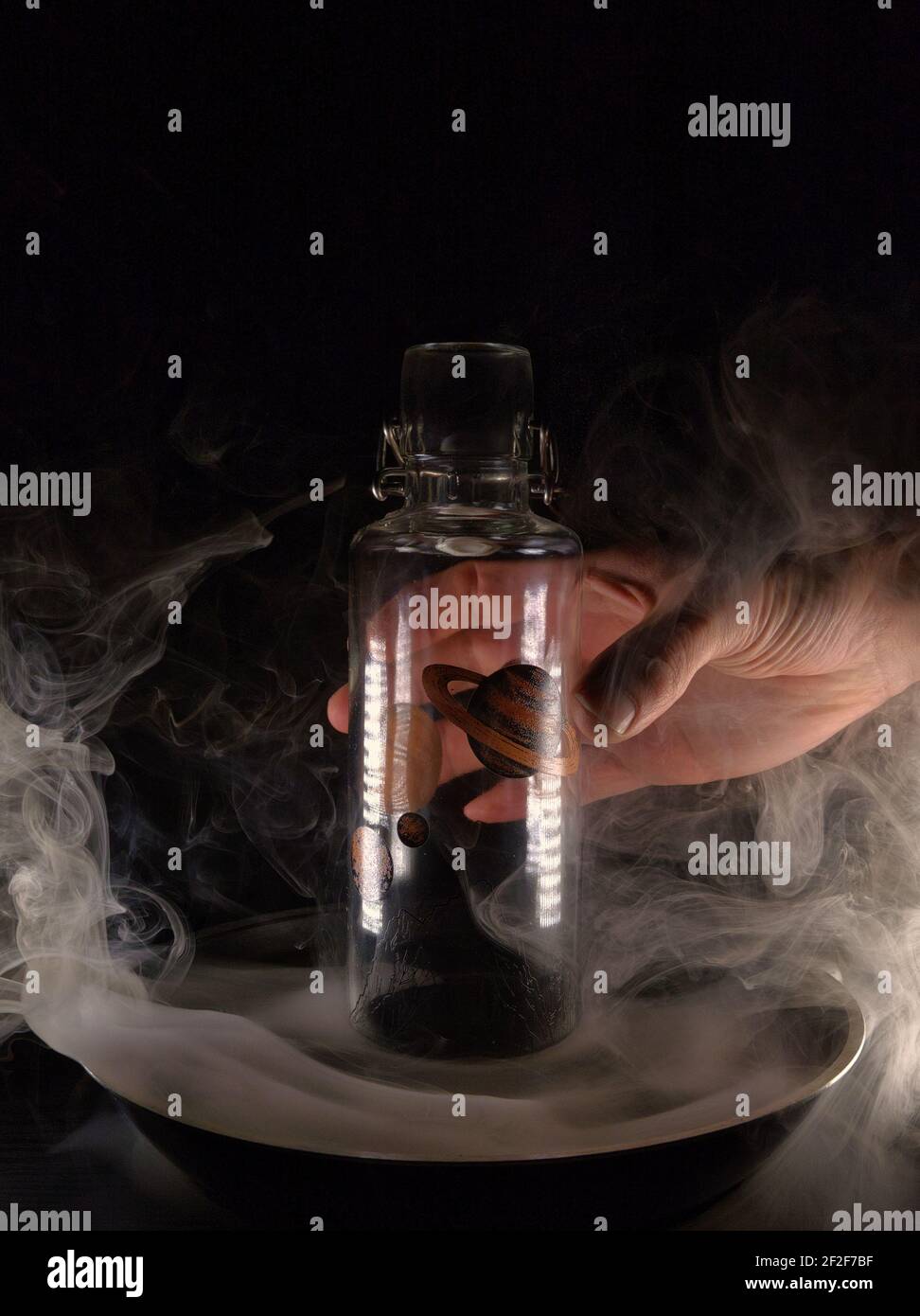 A glass bottle with white smoke around it in the darkness Stock Photo ...