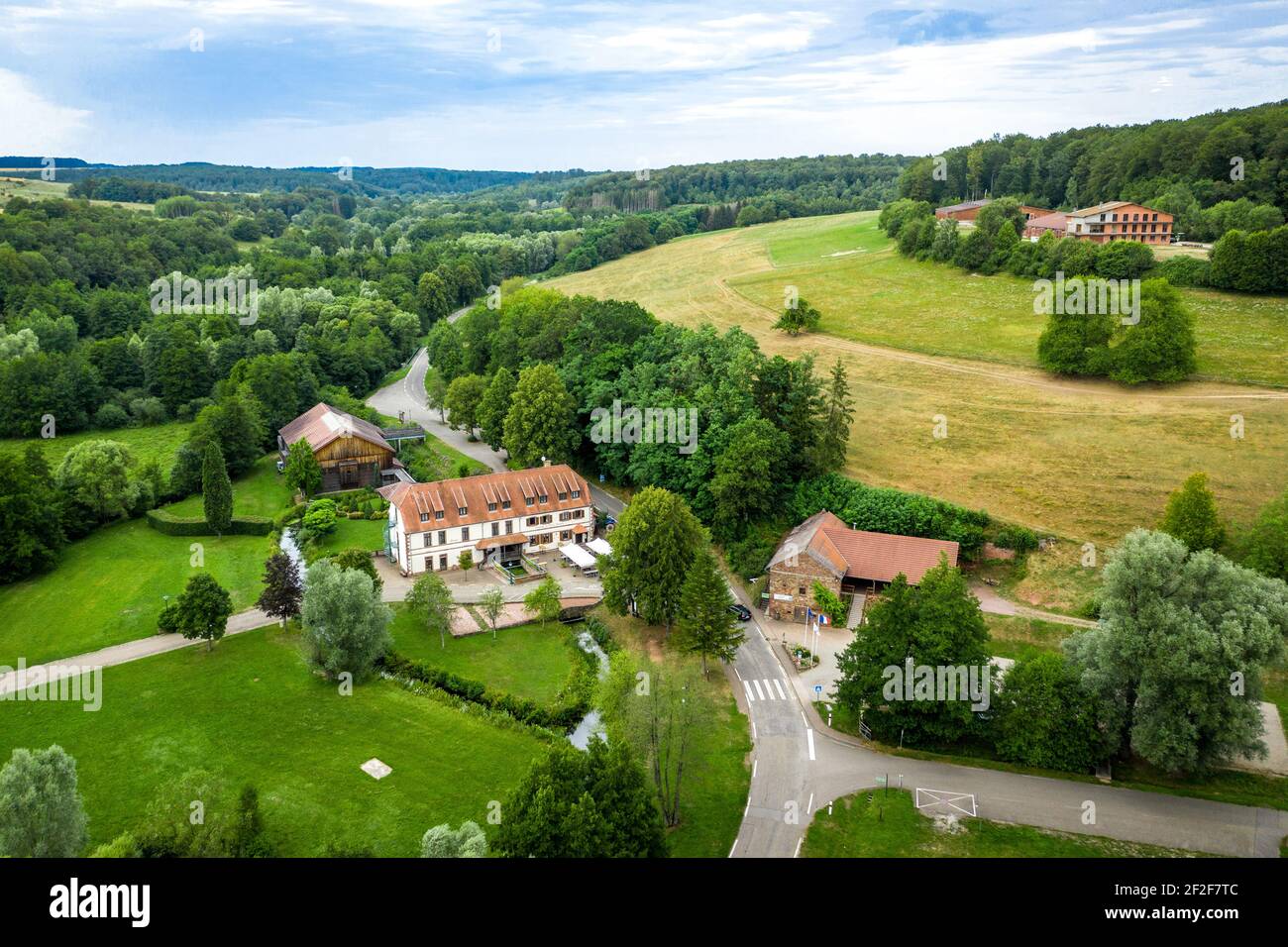 Drone view on several buildings along road on French countryside. Trees ...
