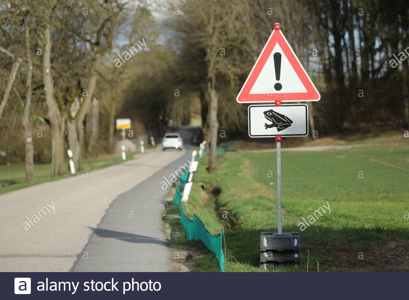 A red warning sign for drivers on a country road in Germany as frogs ...