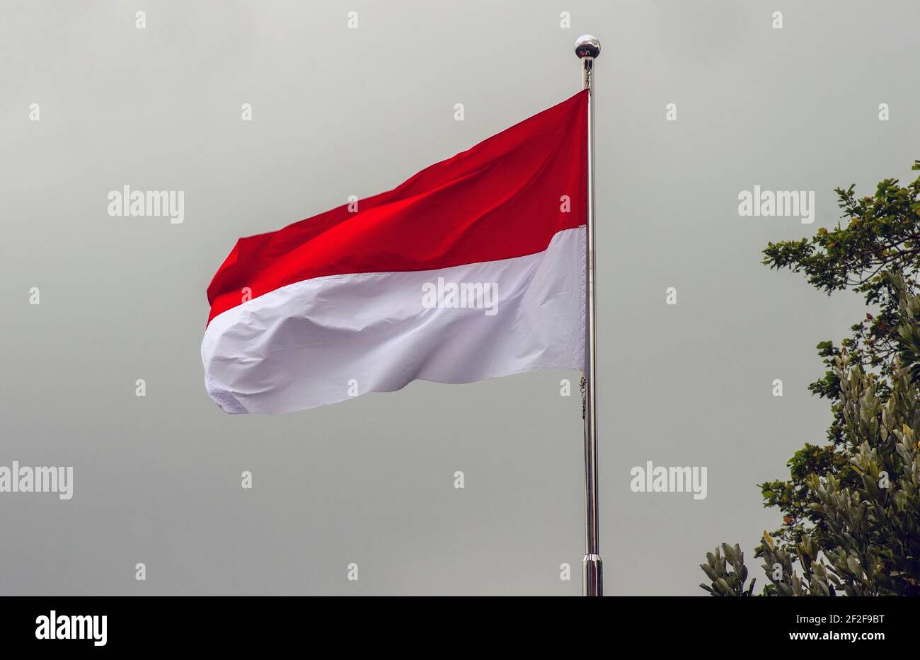 Indonesia and Monaco national flag with white cloudy sky background ...