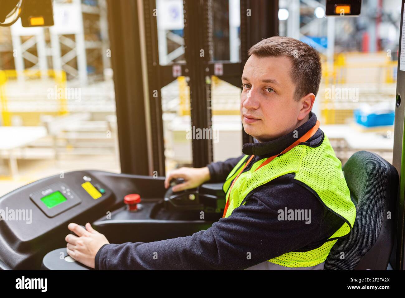 Storehouse employee in uniform working on forklift in modern automatic ...