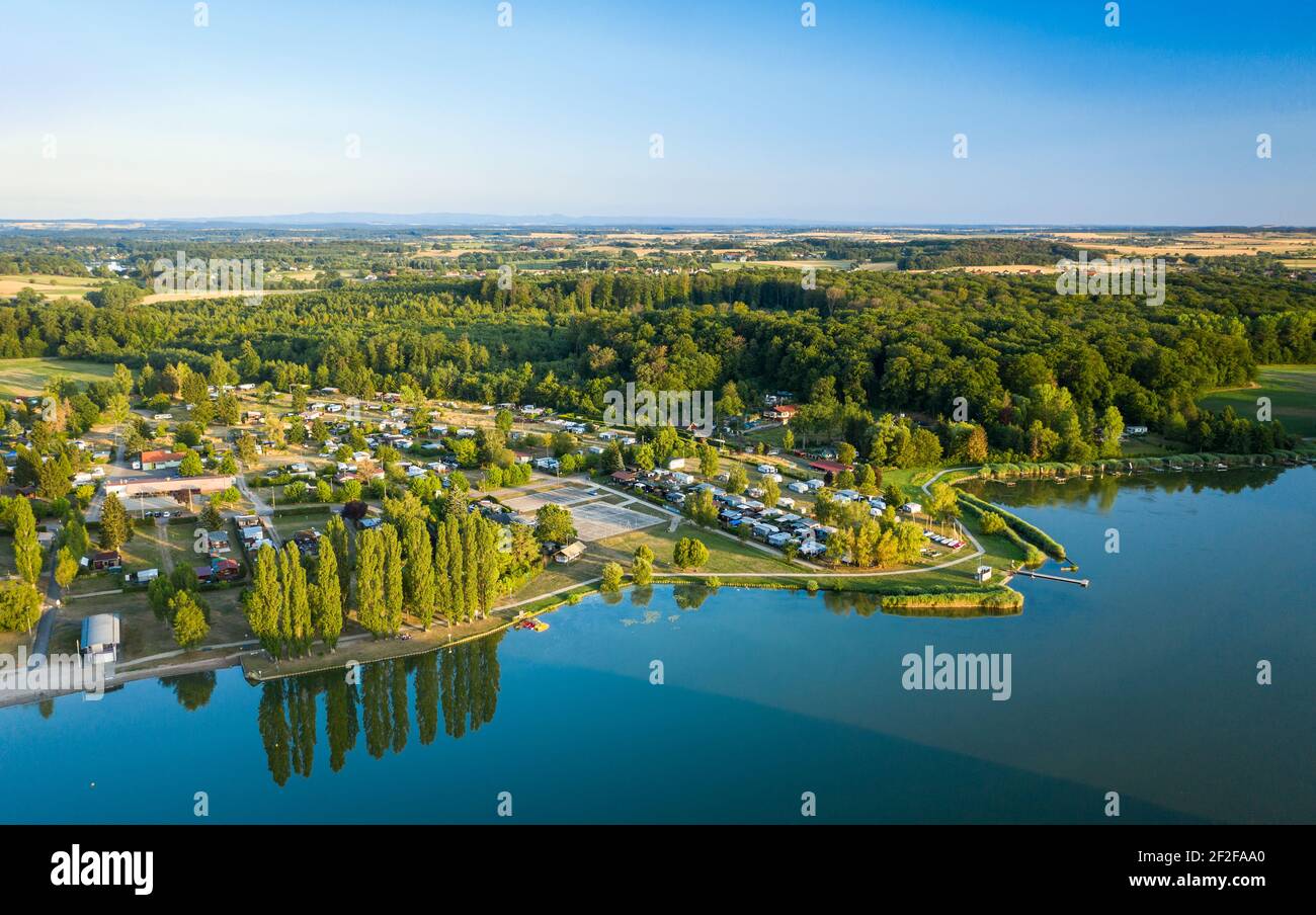 High angle view of lake bank with tall trees and several buildings ...