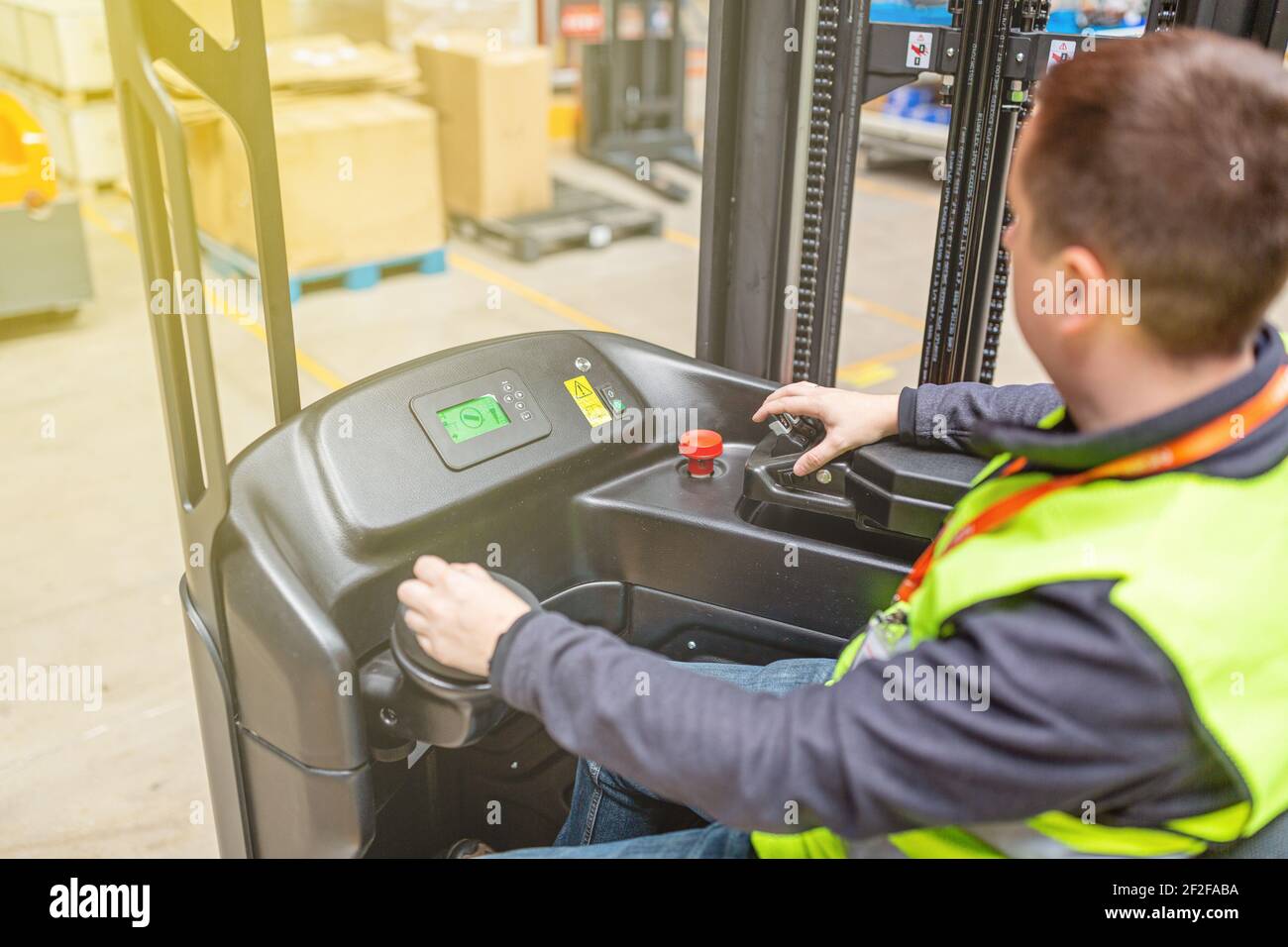 Storehouse employee in uniform working on forklift in modern automatic ...