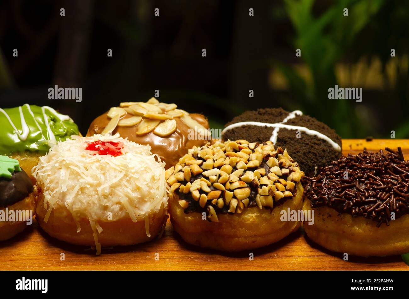Colorful homemade mini donuts in shallow focus with dark background ...
