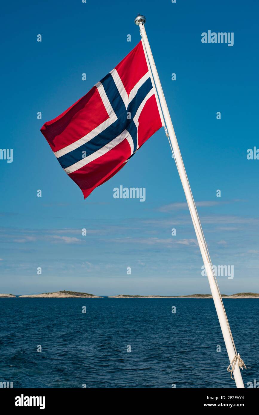 Full National Flag Of Norway On Flagpole With Lofoten Background Stock