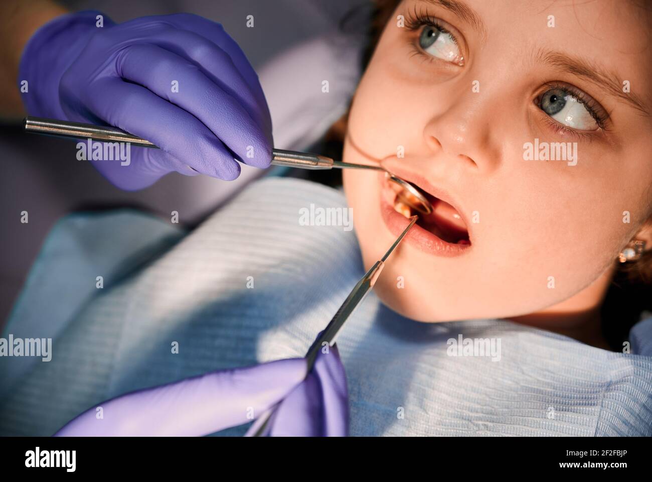 Female dentist examining little girl teeth in dental office Stock Photo ...