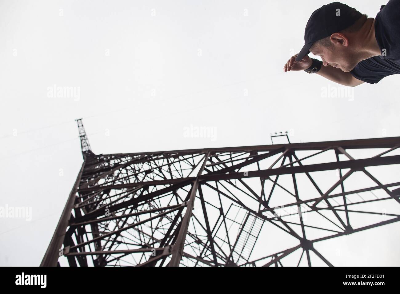 A man looks up at an electric tower Stock Photo - Alamy