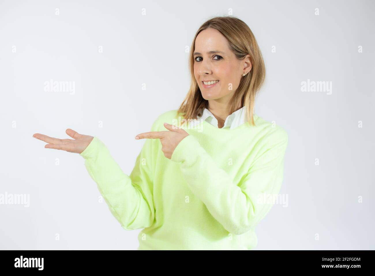Smiling woman pointing finger side. Isolated portrait on white Stock ...