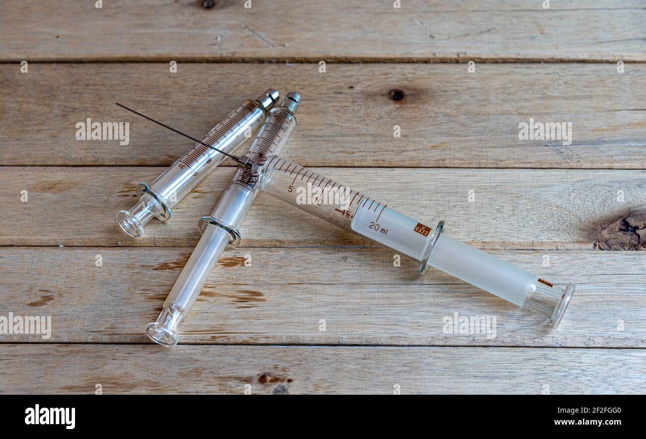 Medical syringes. Glass syringes. Utensils to combat covid-19. Wood ...