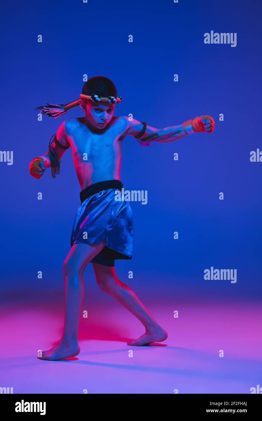 Young boy thai boxer training over blue background in neon light Stock ...
