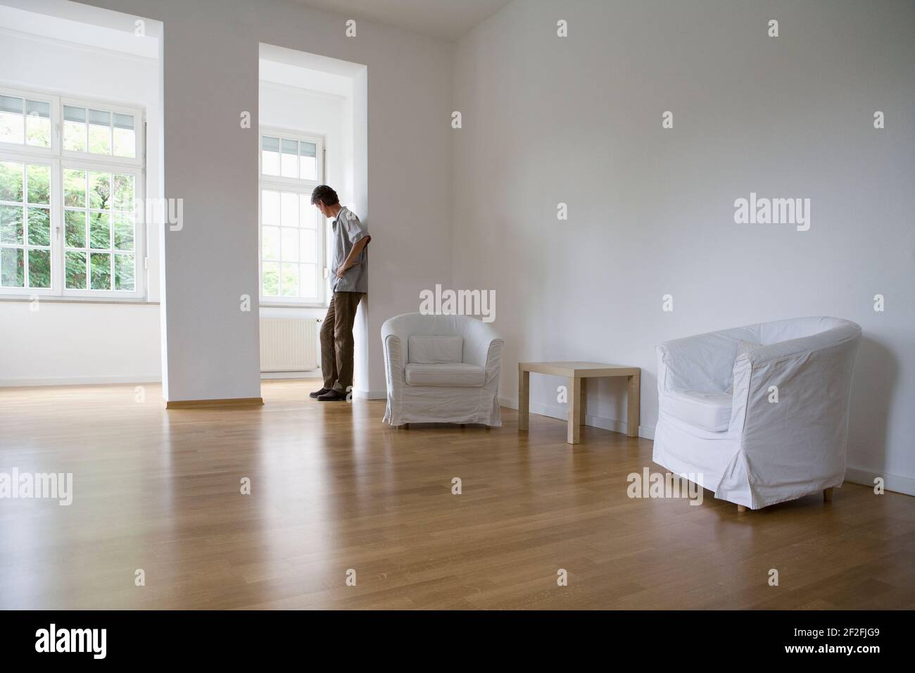 Man stands thoughtfully in a room Stock Photo - Alamy