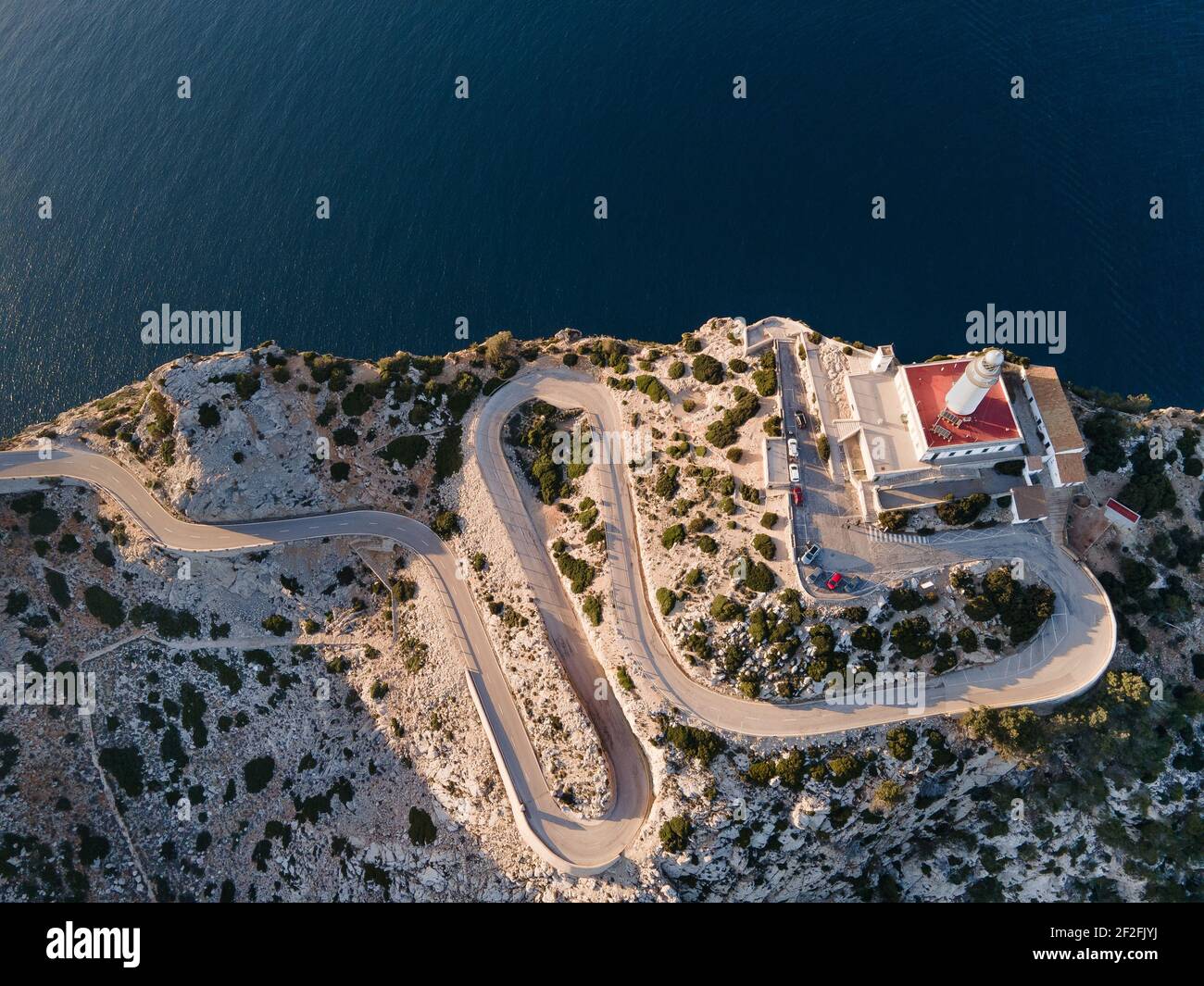 Formentor cape lighthouse and curved road in Majorca at sunset aerial ...