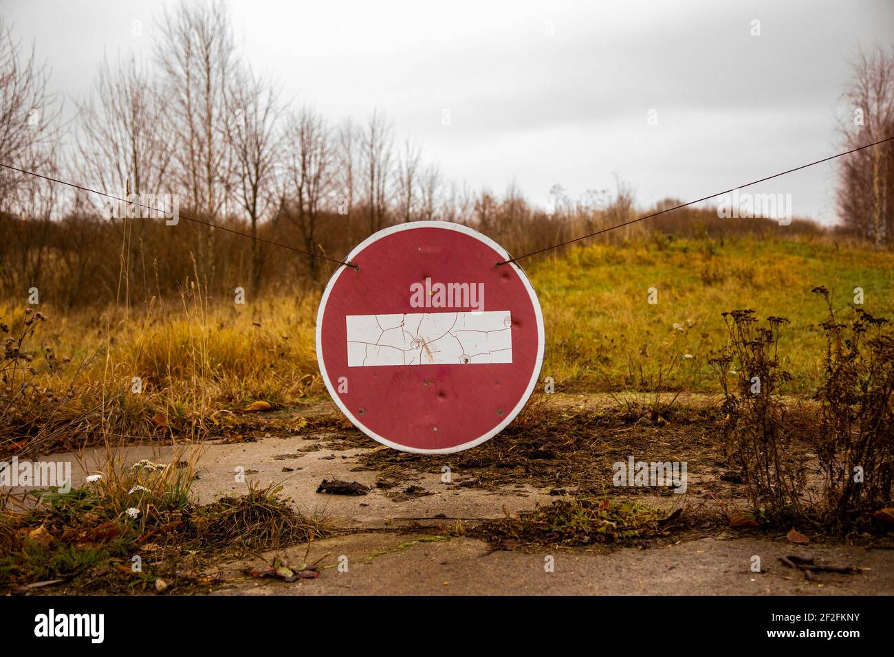 old rusty no entry sign on an old abandoned road in a field. close up ...