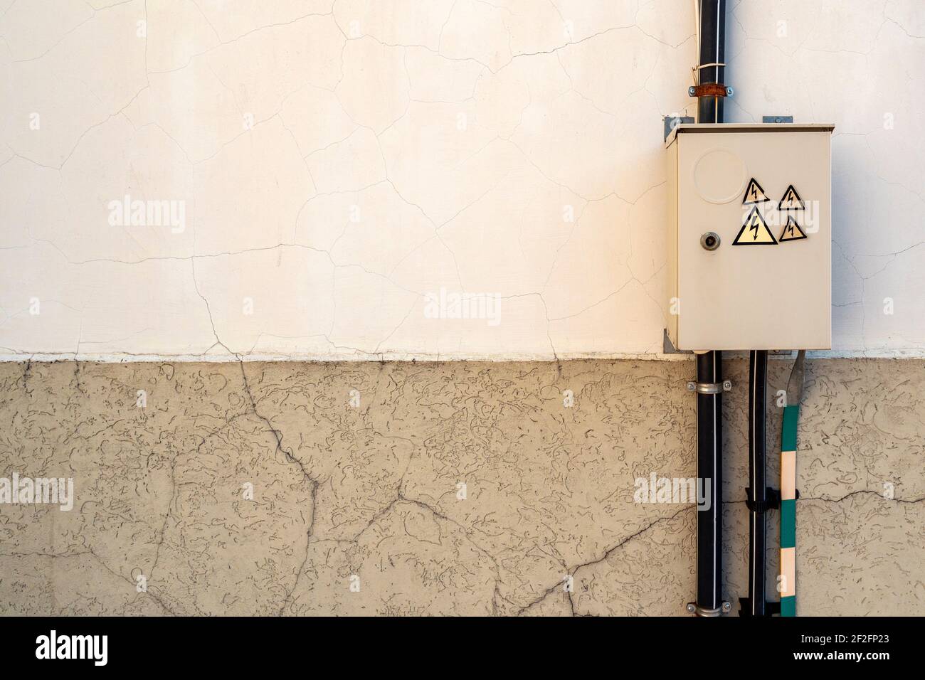 Locked electric panel with hazard sign on the grey wall of transformer ...