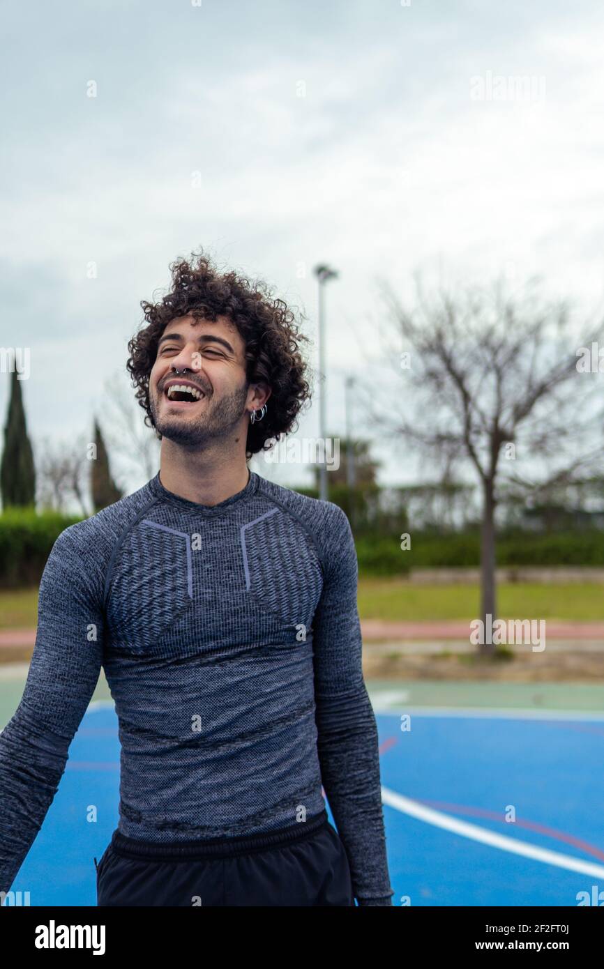 A vertiportrait of a young Caucasian athlete smiling without a mask ...