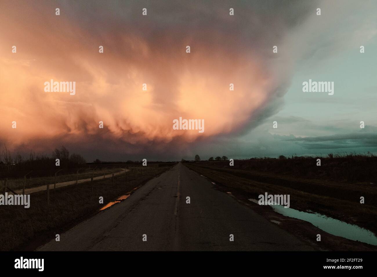 Angry clouds at sunset over a straight road in the UK Stock Photo - Alamy
