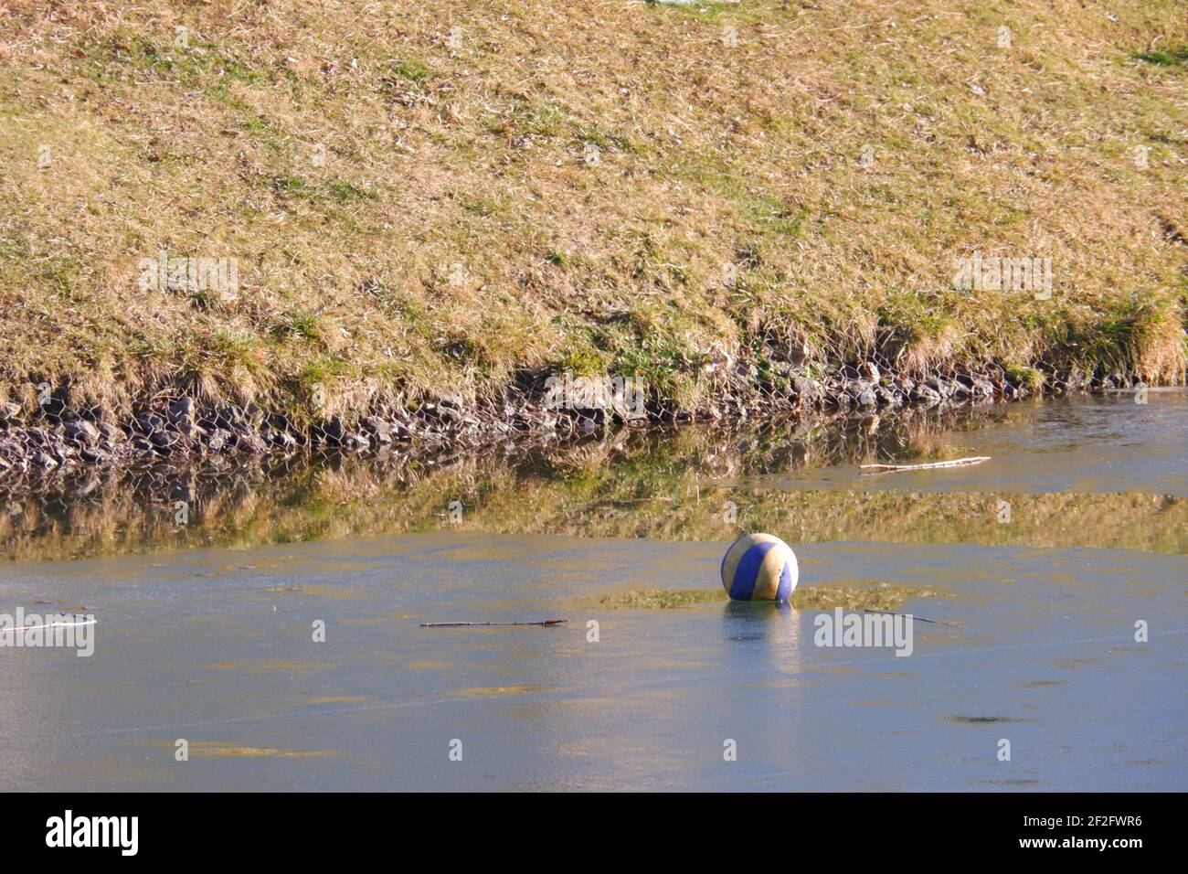 Ball Floating on Frozen River at park Stock Photo - Alamy