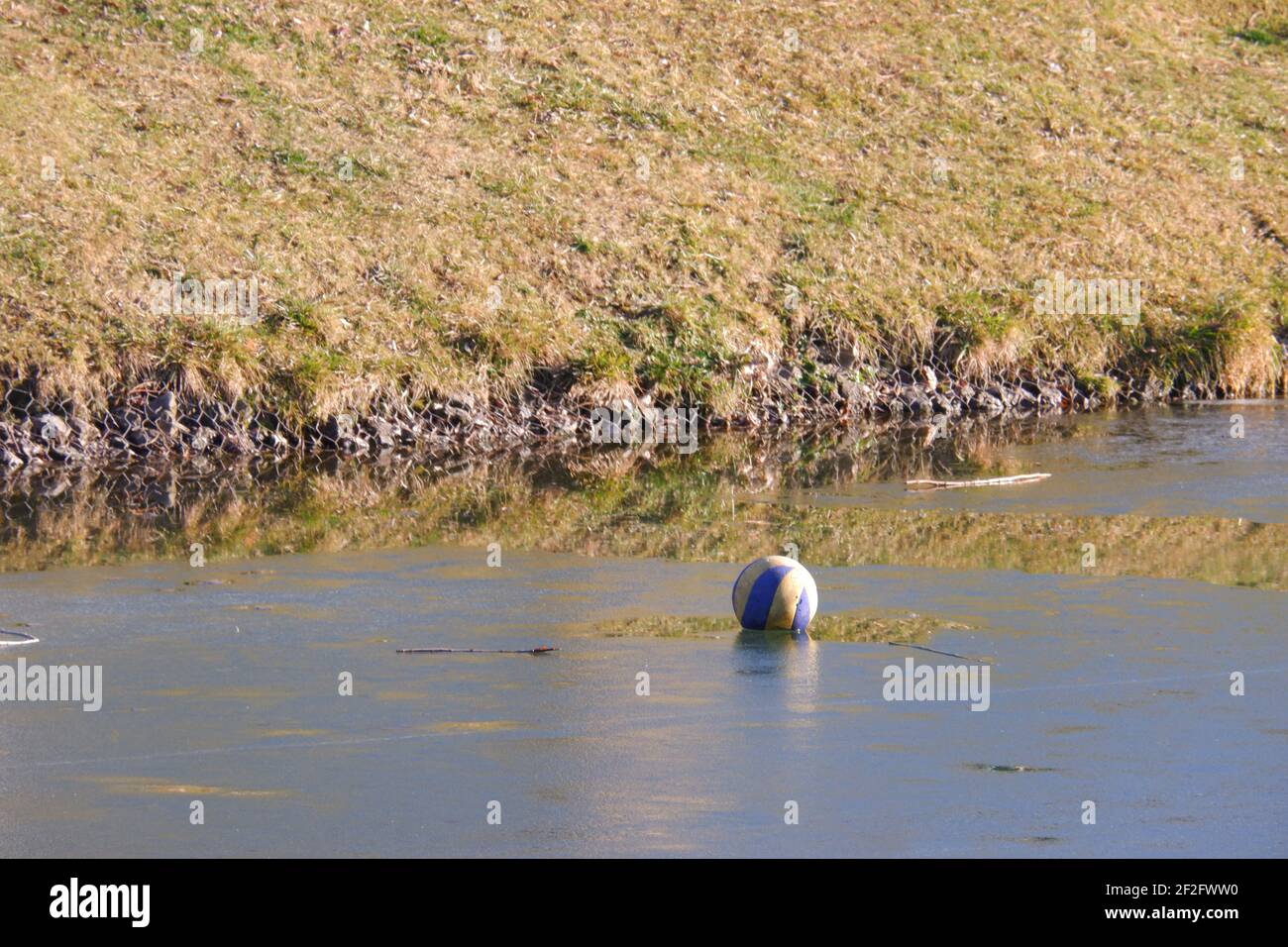 Ball Floating on Frozen River at park Stock Photo - Alamy
