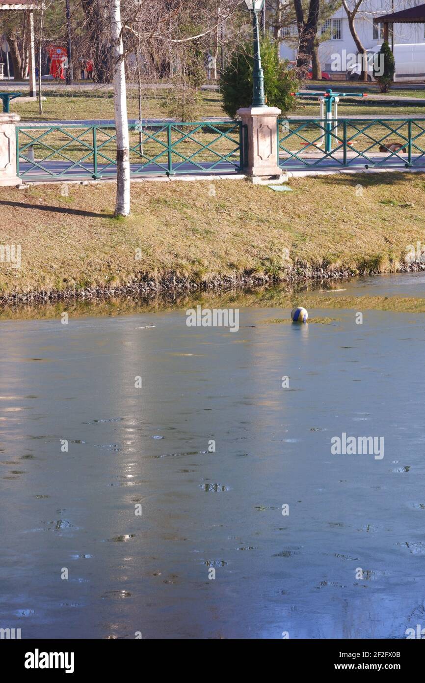 Ball Floating on Frozen River at park Stock Photo - Alamy