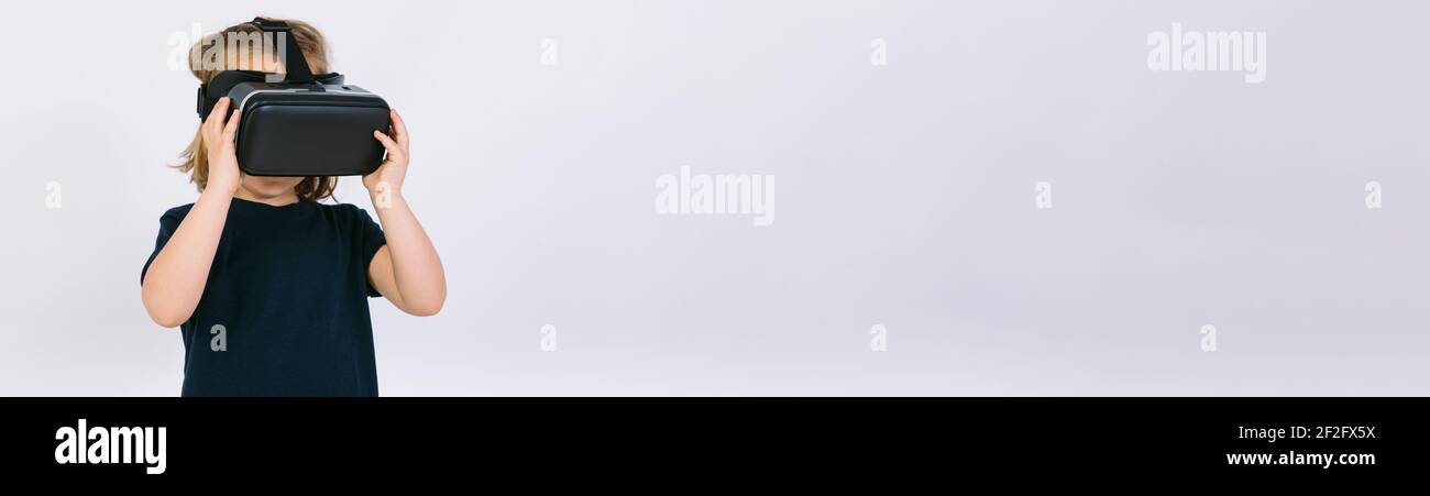 Little girl wearing virtual reality glasses, on white background ...
