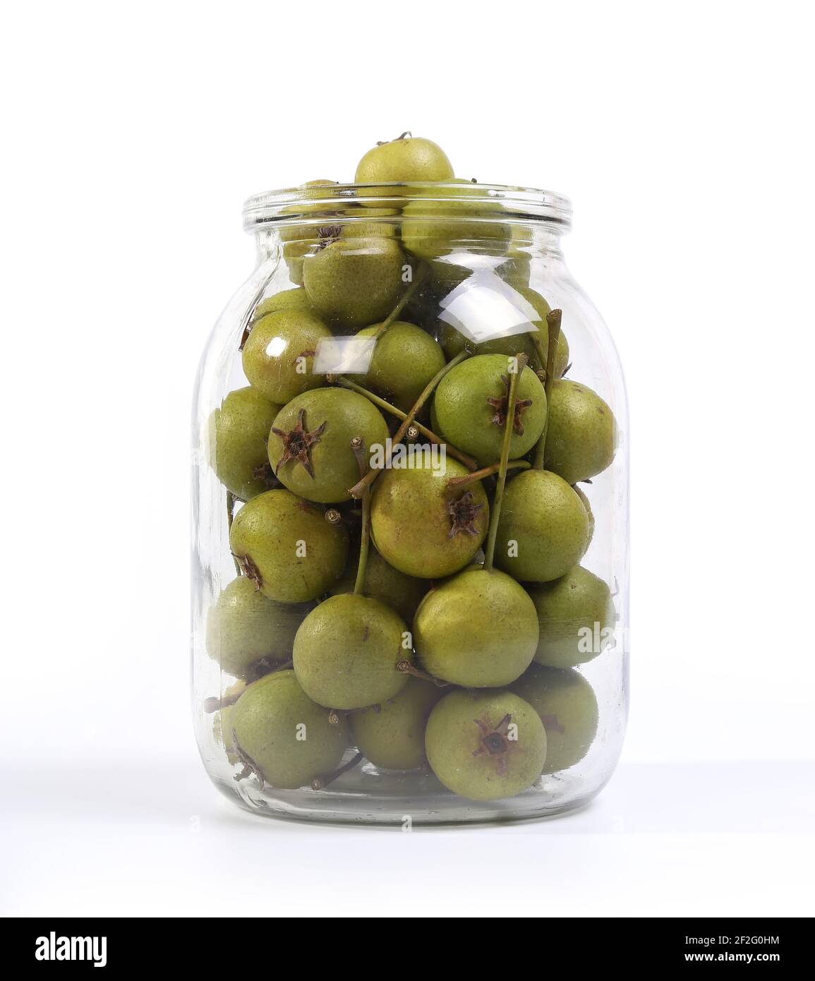 natural small green pears in a glass jar, isolated on white background ...