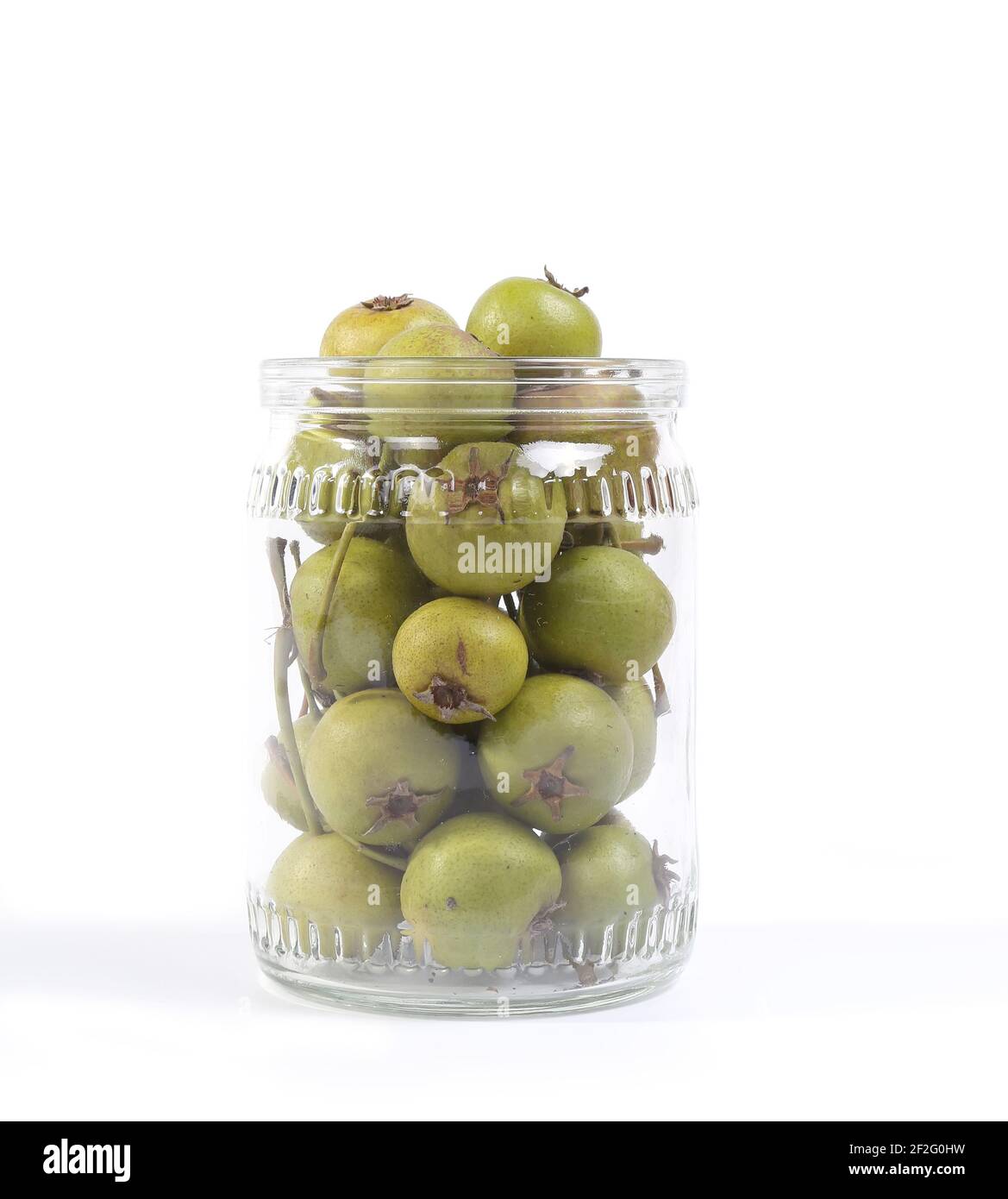 natural small green pears in a glass jar, isolated on white background ...