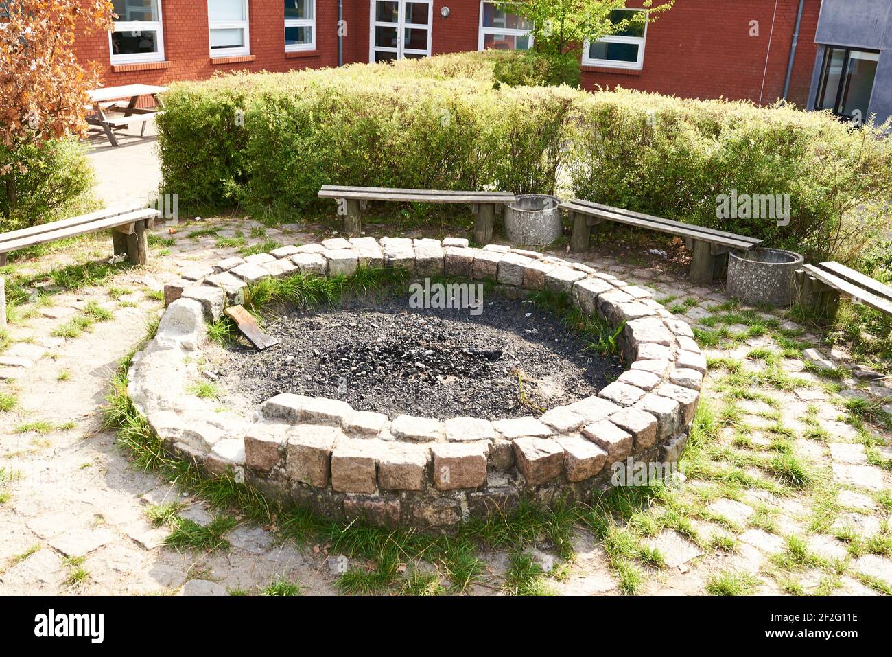 A handmade fireplace outdoors with seating at a school Stock Photo - Alamy