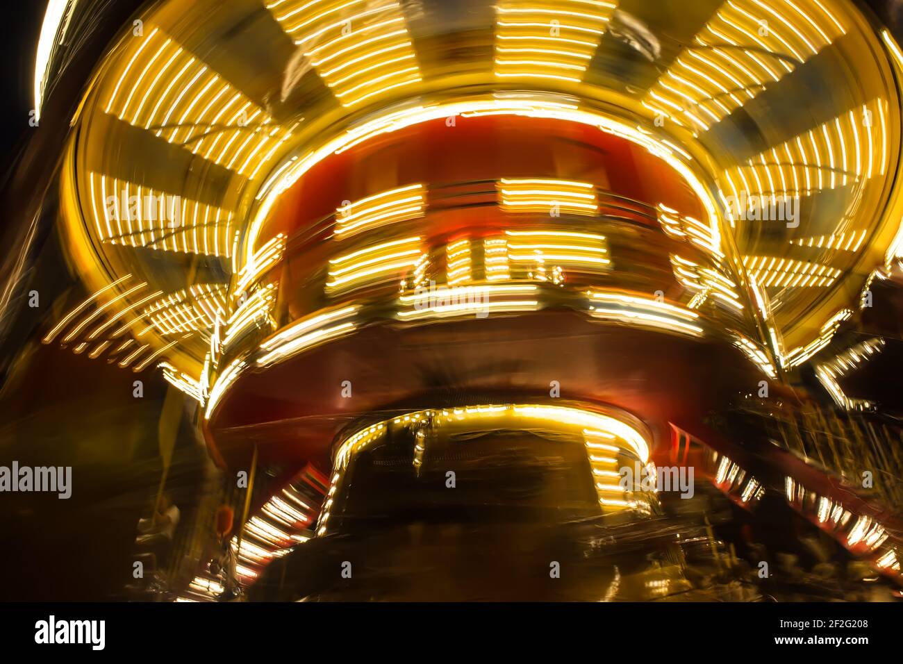 rotating lighted children's merry-go-round at night. Blurred motion ...
