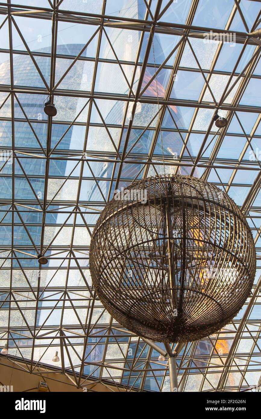 view of office buildings through the glass roof of a shopping center ...