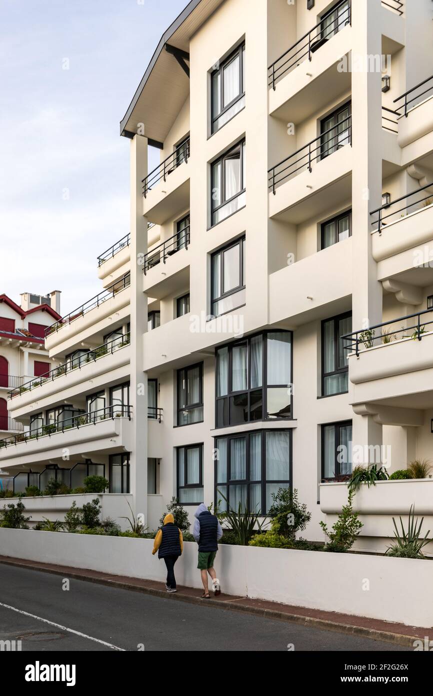 Two hooded people walking in the street of Saint Jean de Luz, France ...