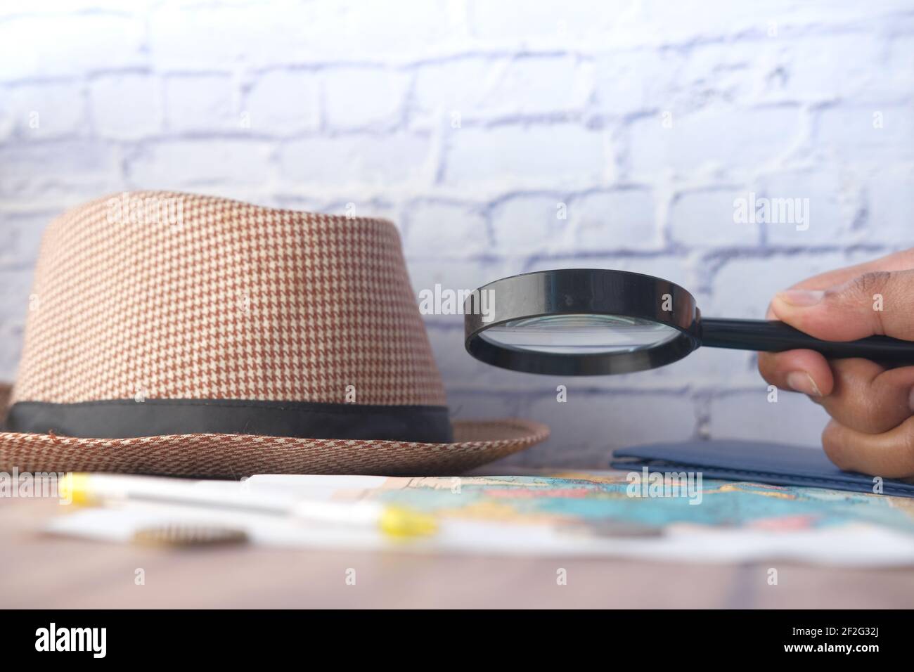 young man using magnifying glass looking something on map Stock Photo ...