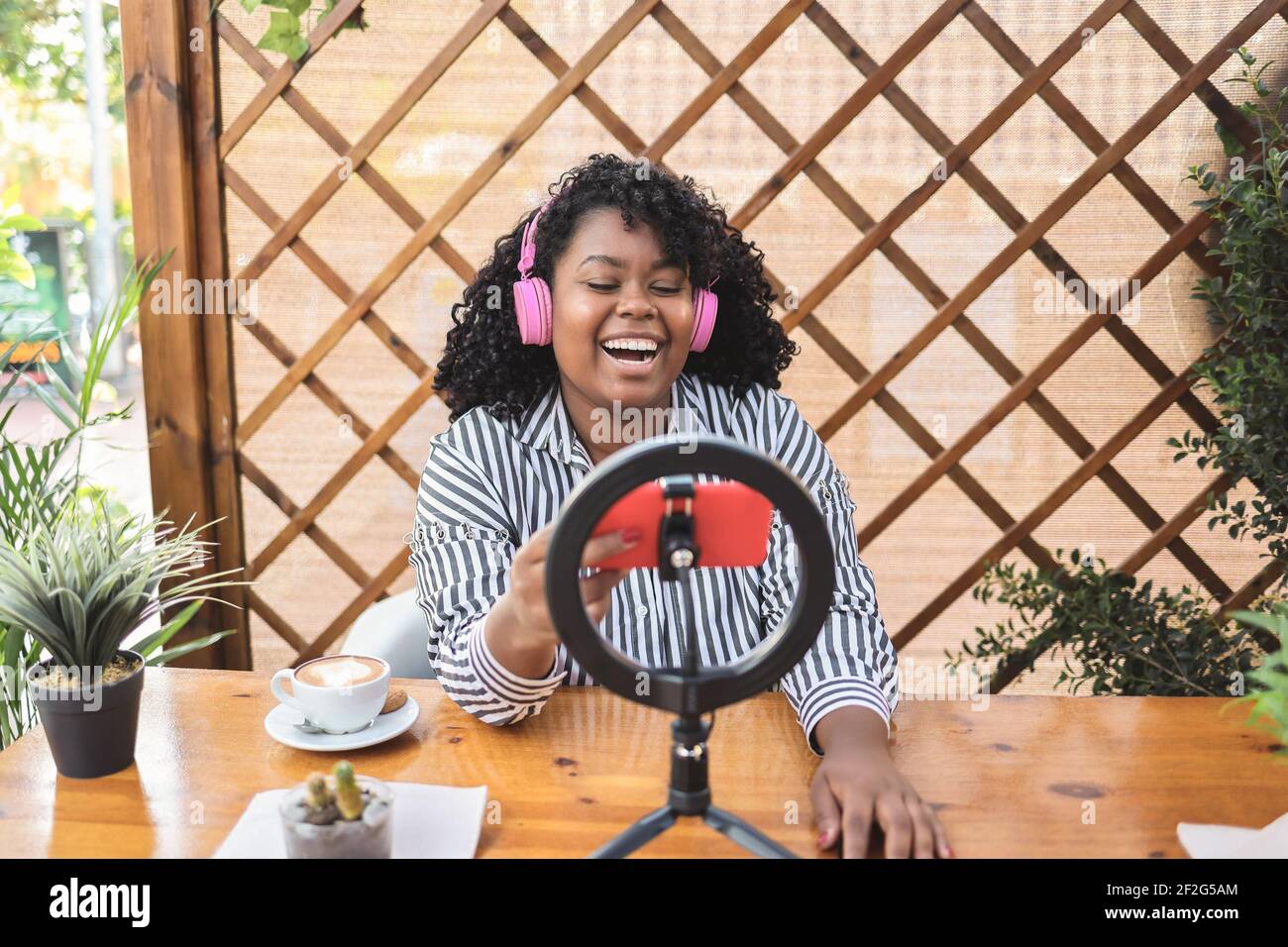 African woman streaming online with mobile phone camera outdoors at ...