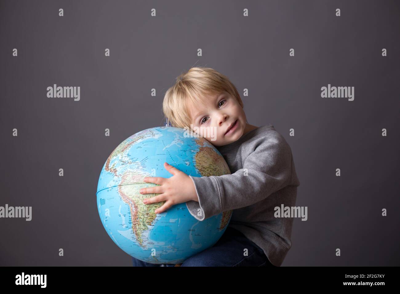 Cute toddler child, boy, hugging big globe, isolated image Stock Photo ...