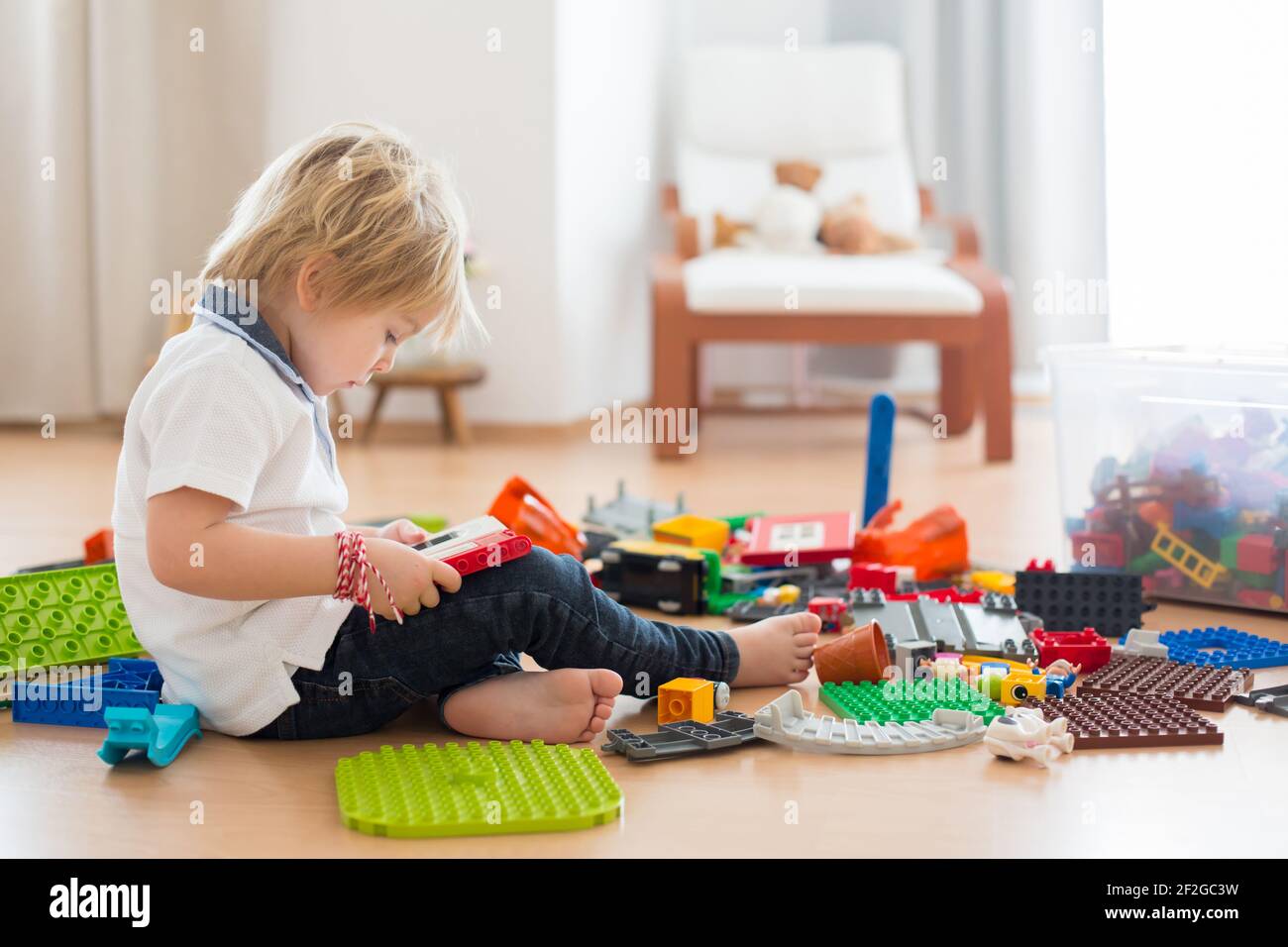 Cute child, playing with colorful toy blocks. Little boy building house ...